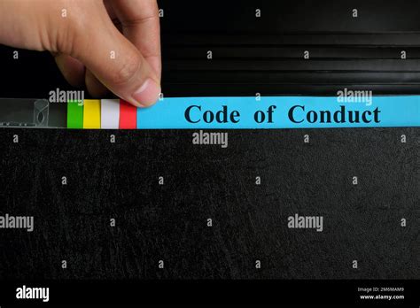 Hand Picking Code Of Conduct File Record In Black Binder Folder Company Code Of Conduct Ethical
