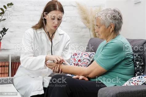 บุคลากรทางการแพทย์ใช้หูฟังเพื่อตรวจสอบอัตราการเต้นของชีพจรในผู้ป่วยสูงอายุ ตรวจสุขภาพ ภาพสต็อก