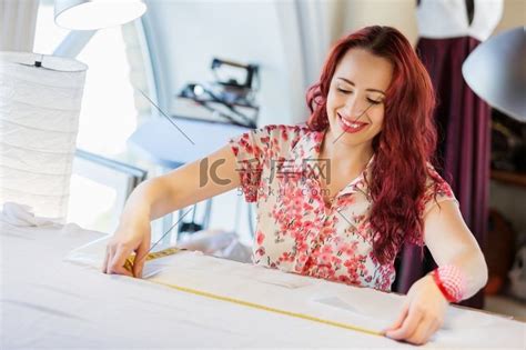 在裁缝工作室。漂亮的裁缝正在制作面料的图案高清摄影大图 千库网