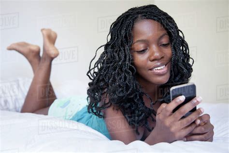Black Woman In Bed Texting