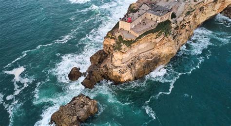 Aerial View Of An Old Lighthouse On A Cliff With A Fortress On The