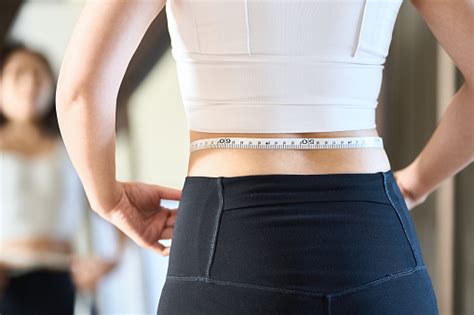 다이어트 결과를 확인하는 아시아 여성허리 측정 측정 거울 뒷모습 여자 일본 얼굴없는 업적 손 허리 허리 위 줄자 보기 내장 지방 체지방 확인 허리에 대한 스톡 사진 및 기타