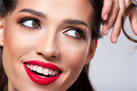 갈색 머리를 가진 젊은 미소 여자 얼굴의 깨끗한 피부를 가진 갈색 머리 여자 밝은 빨간 립스틱 모델의 초상화 밝은 메이크업과 행복한 패션 모델 스튜디오에서 포즈 행복 개념