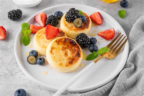 코티지 치즈 팬케이크 시르니키 신선한 딸기 꿀 사워 크림을 곁들인 리코타 튀김이 회색 콘크리트 배경에 있습니다 건강하고 맛있는 아침 식사 평면도 복사 공간 0명에 대한 스톡