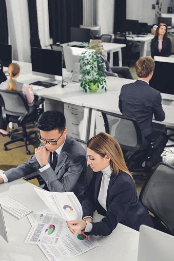 집중된 사업가 사업가 데스크톱 컴퓨터를 사용 하 고 사무실에서 차트 작업의 높은 각도 보기 기업 비즈니스에 대한 스톡 사진 및