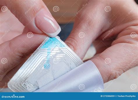 Woman Removing An Electronic RFID Device Made For Anti Theft Purposes From Clothing Shoplifting