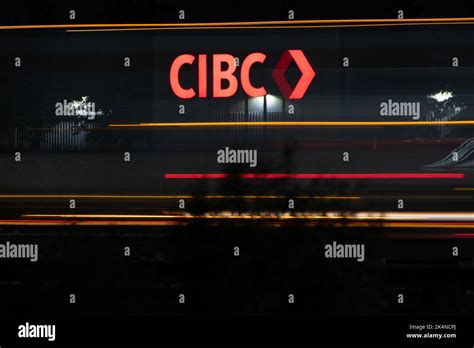 The Cibc Logo Illuminated On A Sign Seen At Night Along A Busy Highway