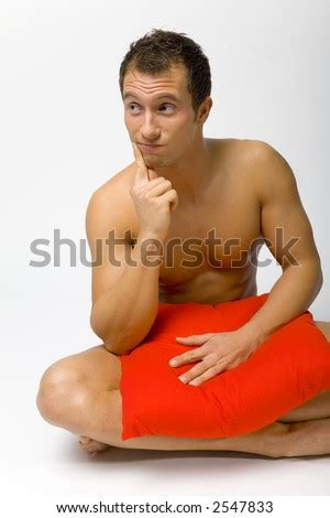 Nacked Man Sitting Hiding His Body By Pillow And Thinking Stock Photo