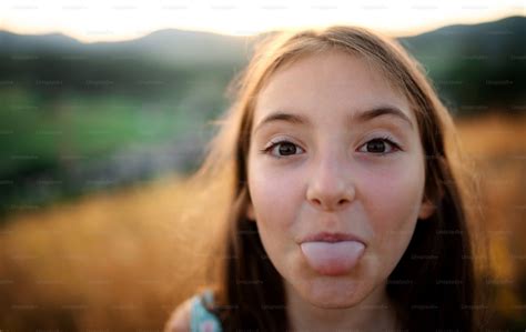 혀를 내밀고 있는 자연 속의 어린 소녀의 얼굴 사진 사진 Unsplash의 못생긴 사람들 이미지