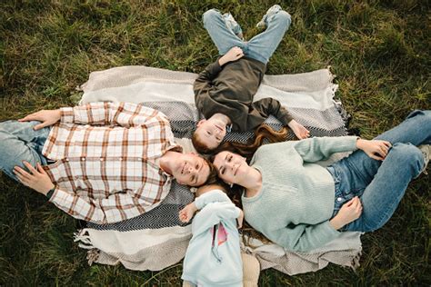 가을날 자연에서 함께 시간을 보내는 가족 엄마 아빠 아이들이 여름 푸른 잔디밭에 담요를 깔고 누워 있다 플랫 레이 평면도 어머니