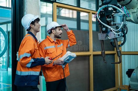 Group Of Robotics Engineers Working With Programming And Manipulating