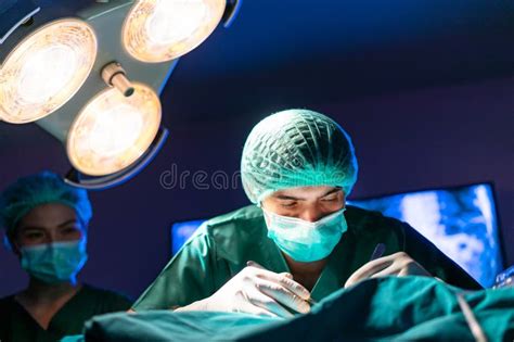 Doctors During Operation In Hospital Operating Room With Patient Stock