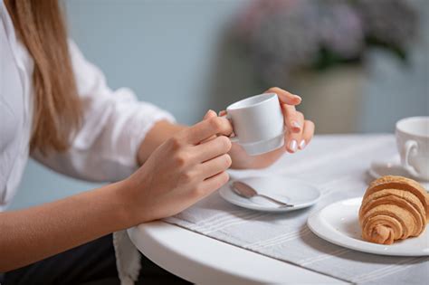 커피 컵을 들고 여성의 손의 측면보기 프랑스 카페에서 커피 브레이크를 가진 여자 프랑스 스타일의 레스토랑에서 커피를 마시는 여성