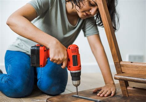 Woman Using Hand Drill To Assemble A Wooden Table Premium Photo