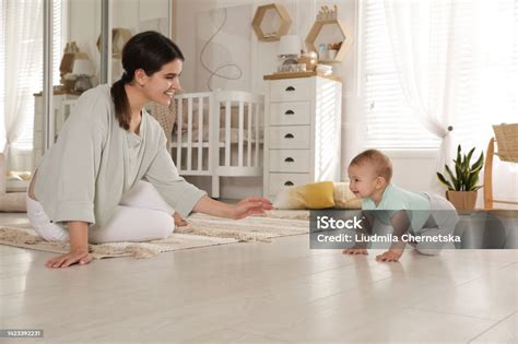 귀여운 아기가 집에서 바닥에서 기어 다니는 것을 지켜 보는 행복한 젊은 어머니 25 29세에 대한 스톡 사진 및 기타 이미지 25 29세 2명 6 11 개월 Istock