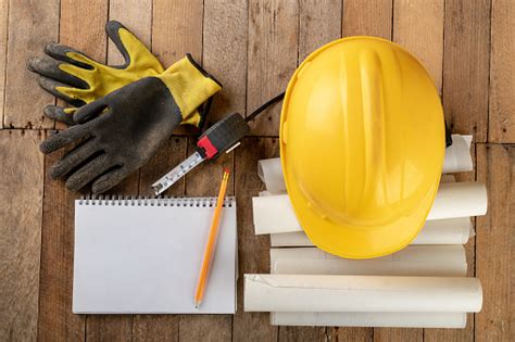 건설 헬멧 및 디자인 양피지의 롤 나무 테이블에 건설 엔지니어 액세서리 어두운 배경입니다 개념에 대한 스톡 사진 및 기타 이미지 Istock