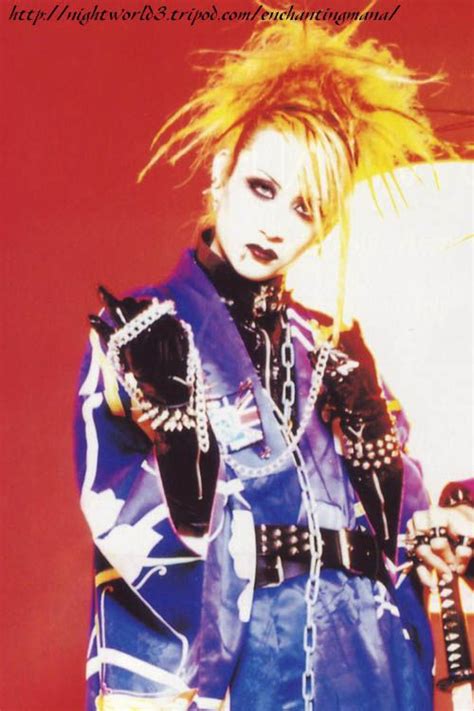 A Woman With Blonde Hair And Piercings Holding A Pair Of Scissors