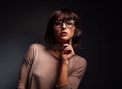 красивая сексуальная строгая женщина с розовой помадой в модных очках глядя на темный теневой