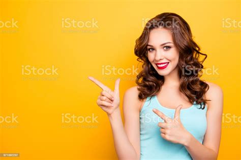 쾌활 한 긍정적인 요 염 한 몸짓 빈 복사본 공간을 보여주는 2 개의 Forefingers의 장소 카메라 노란색 배경 광고