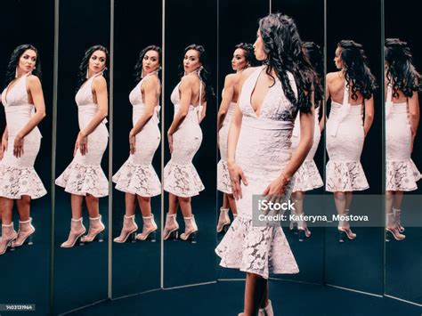 하얀 신발과 거울 근처에 서있는 흰 드레스를 입은 아름다운 갈색 머리 여인의 초상화 가정의 방에 대한 스톡 사진 및 기타 이미지