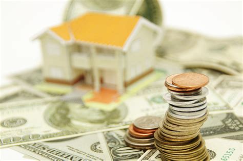 유토이미지 달러 지폐더미 위에 있는 동전과 집