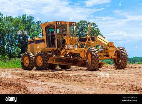 An Earthmoving Construction Grader Tractor At Construction Site Stock