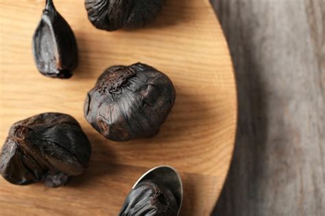 Premium Photo Black Garlic Allium Sativum On Wooden Board