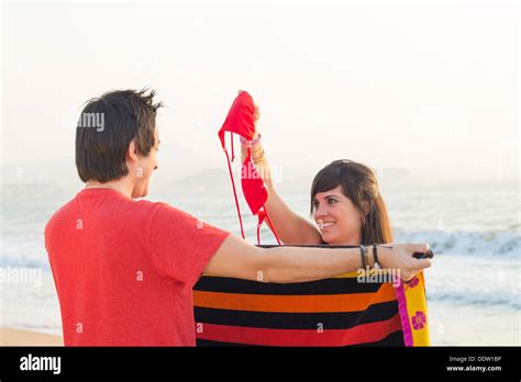 Mädchen Umziehen Am Strand Und Hänseleien Ihrem Freund Stockfotografie