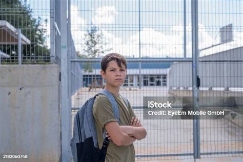 자신감 넘치는 소년의 초상화 와 팔짱을 끼고 금속 문에 대항하여 서 있는 12 13세에 대한 스톡 사진 및 기타 이미지 12 13세 건축 게이트 Istock