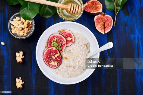 진한 파란색 배경에 무화과 조각과 호두가있는 죽 한 그릇 플랫 레이 공간을 복사합니다 맨 위 보기 가을에 대한 스톡 사진 및 기타 이미지 Istock