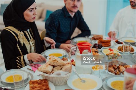 잔치를 깨기 위해 이프타르 저녁 식사를 하는 무슬림 가족 라마단 축제 기간 동안 집에서 전통 음식을 먹습니다 현대 가정에서의 이슬람 할랄 먹고 마시기 Ramadan