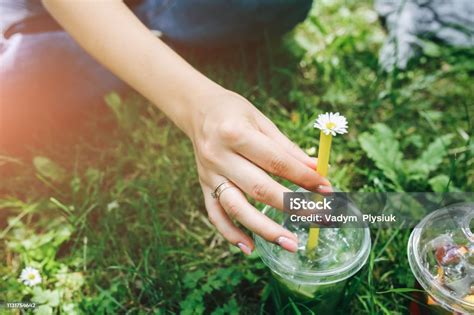 여자는 잔디에 손에 여름 칵테일을 들고 있습니다 차가운 무알코올 음료가 얼음으로 이동 합니다 모 히 토와 딸기 레모네이드 라임