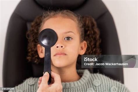 검안 안과 진료 및 의료 광학 클리닉에서 교합기로 시력 검사를 받는 소녀 건강한 시력을 위해 광학 도구로 시력 검사를 하는 브라질의 검진사 검안사 및 어린이 8 9 살에