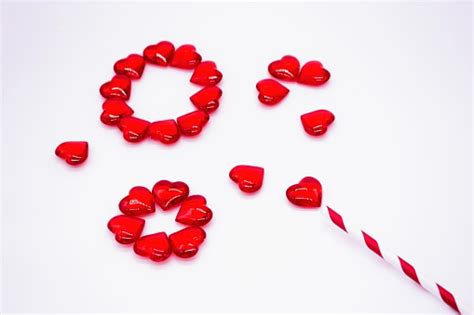 밝은 빨간색 반짝이는 유리 하트는 종이 줄무늬 칵테일 짚과 비누 거품처럼 원에 쌓여있다 사랑 결혼식 발렌타인 데이와 낭만적 인 크리스마스의 개념 복사 공간 0명에 대한 스톡