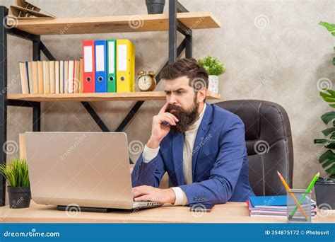 Serious Professional Man In Suit Working On Work Computer In Office