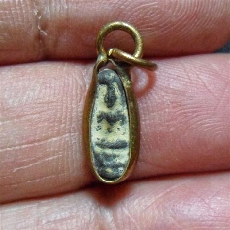 พระพิจิตรเม็ดข้าวเม่า เนื้อชินตะกั่วเก่ามีคราบไขกรุเก่าขึ้น หลังลายผ้า เลี่ยมทองเหลืองจับขอบ