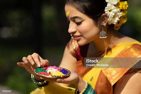 색상의 홀리 축제를 축하하기 위해 장식 접시에 색상이나 색상이나 Gulal 또는 Abeer 또는 홀리 분말을 배열 정원에서 노란색 새어리 좌석에 아름답고 어린 소녀 또는