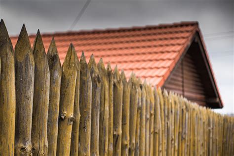 붉은 기와 지붕 목조의 배경에 대해 날카로운 나무 말뚝의 만든 울타리 목재 재료에 대한 스톡 사진 및 기타 이미지 목재 재료 울타리 통나무 Istock