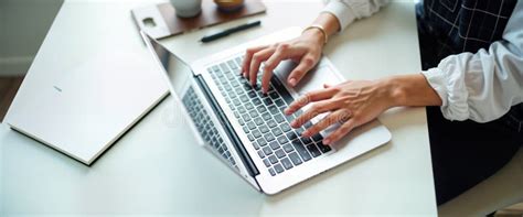 Attractive Businesswoman Sits At White Office Desk Using Laptop Types