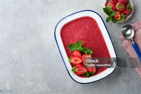 딸기 그라니타 또는 신선한 베리 셔벗이 회색 콘크리트 배경에 하얀 소박한 그릇에 담겨 있다 딸기와 민트를 곁들인 아이스크림 여름 치료 평면도 건강한 식생활에 대한 스톡 사진