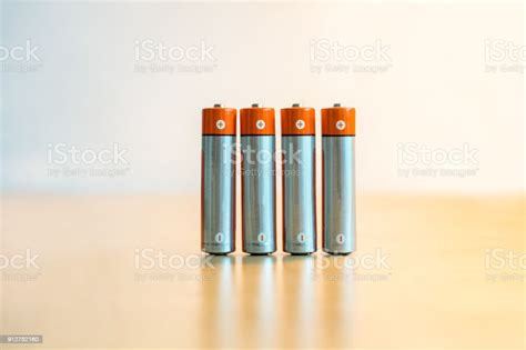 더하기와 빼기 기호 테이블에 서 있는 4 개의 Aa 배터리의 클로즈업 4가지 개체에 대한 스톡 사진 및 기타 이미지 4가지