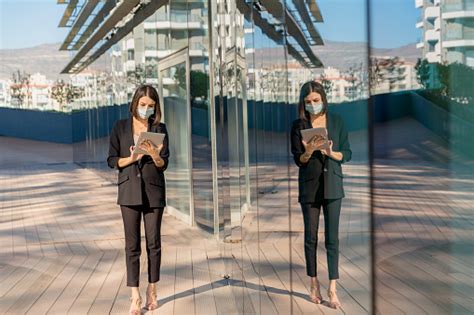 전염병 동안 사무실 건물 밖에서 일하는 얼굴 마스크를 가진 젊은 사업가 건강관리와 의술에 대한 스톡 사진 및 기타 이미지