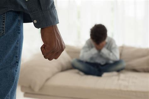 Padre negro apretando el puño amenazando a su hijo asustado en casa recortada Foto Premium