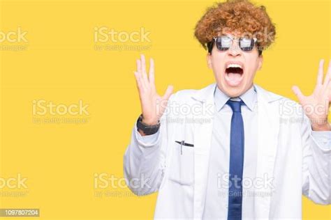 젊은 잘생긴 과학자 남자 전문 코트와 선글라스 무기와 성공을 위한 깜짝 놀라게 하 고 축 하 하 고 오픈 눈 비명 흥분 우승자 개념 선글라스에 대한 스톡 사진 및 기타