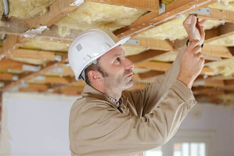 Constructor De Hombres Con Destornillador En El Techo Imagen De Archivo