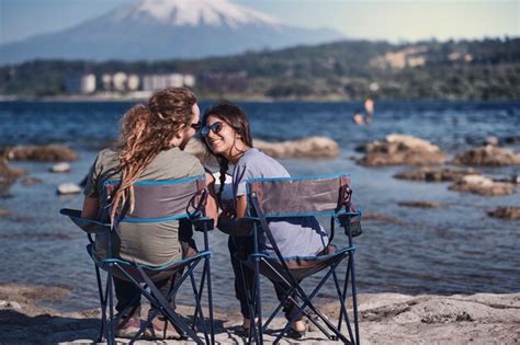 Pareja De Enamorados Sentados En Sillas De Playa Viendo La Puesta De