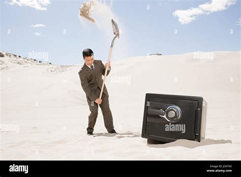 Man Digging By Safe In Desert Stock Photo Alamy