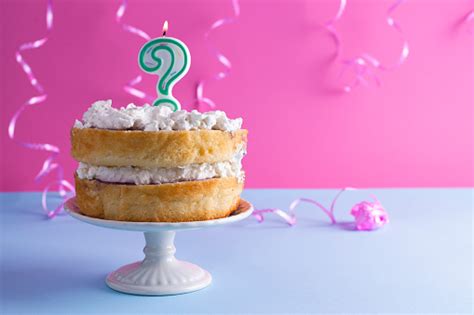 분홍색과 파란색 배경과 틴 셀과 웨이 벌 키에 생일을 위한 흰 크림이 있는 축제 비스킷 케이크 케이크에 물음표 촛불 휴일 광고 포스터 및 텍스트에 대 한 장소 물음표에 대한