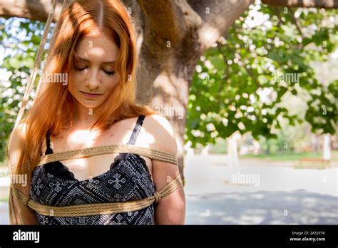 A Slim Pretty Red Haired Girl With Bondage Sexy Pose Has Her Wrists
