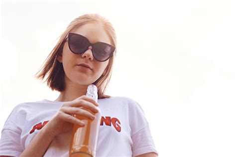 사람 라이프 스타일 및 휴양 개념입니다 꽤 귀여운 여성 젊은이 사과 쥬 스 나 레모네이드 병을 보유 하 고 착용 하는 선글라스와 캐주얼 T 셔츠 흰색 배경 복사 공간에 격리